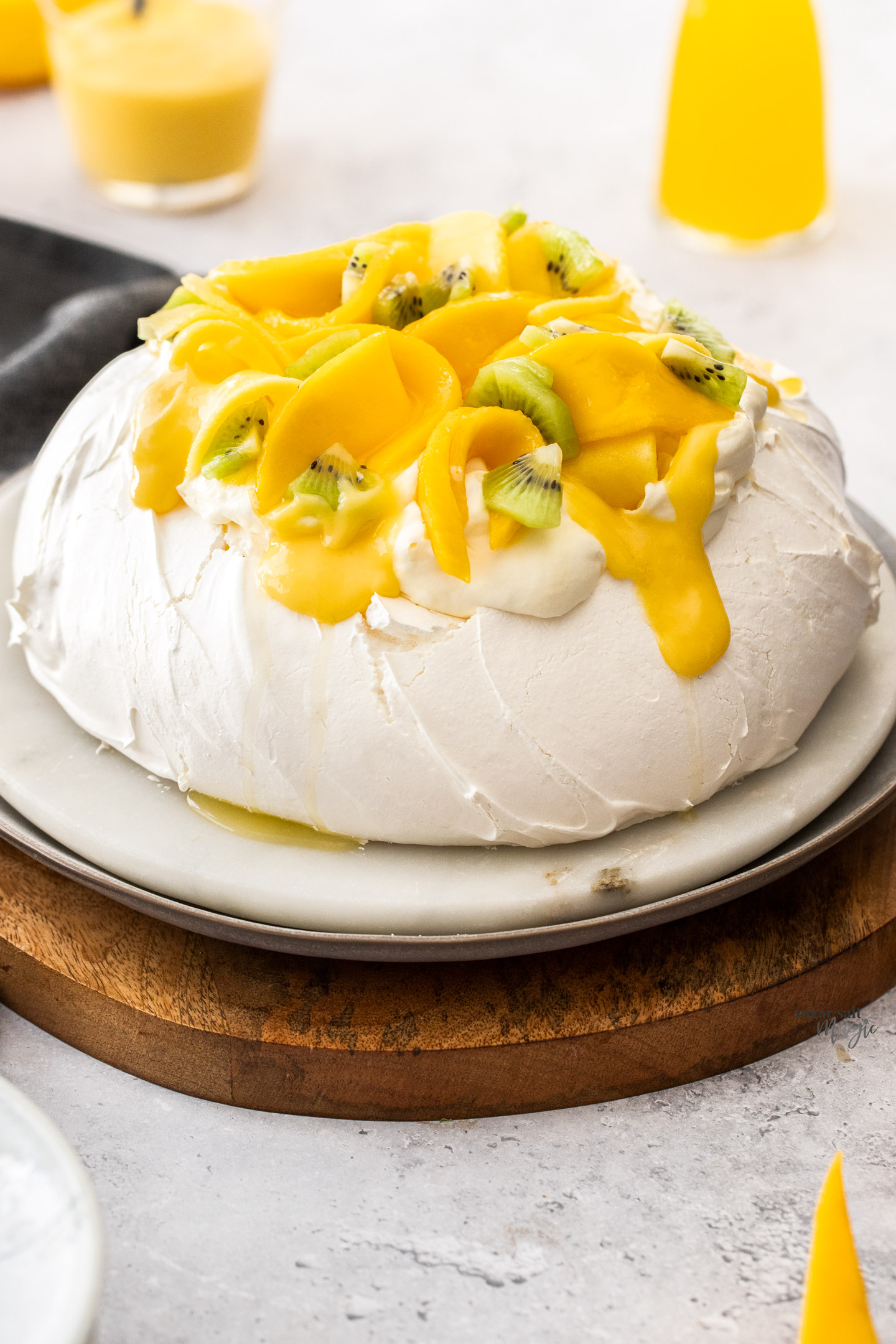 A whole pavlova topped with mango and cream.